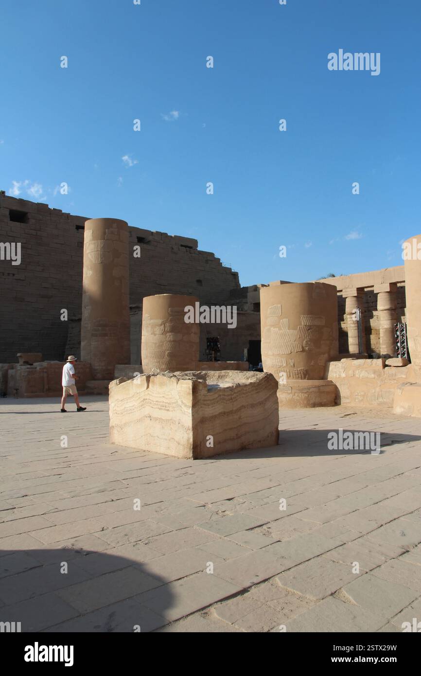 A man and the ruins of the kiosk of Taharqa at the first courtyard of ...