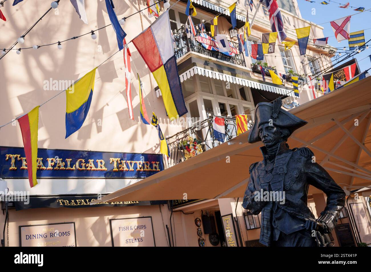 Naval nautical flags hang above the statue of Admiral Lord Nelson at ...