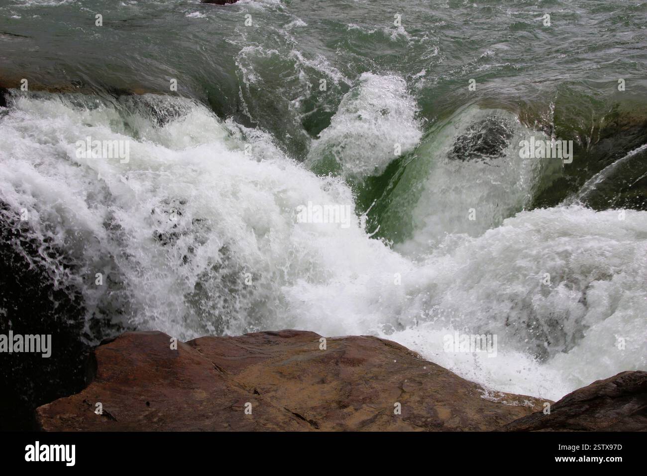 The image captures a dynamic scene of rushing water over a large ...