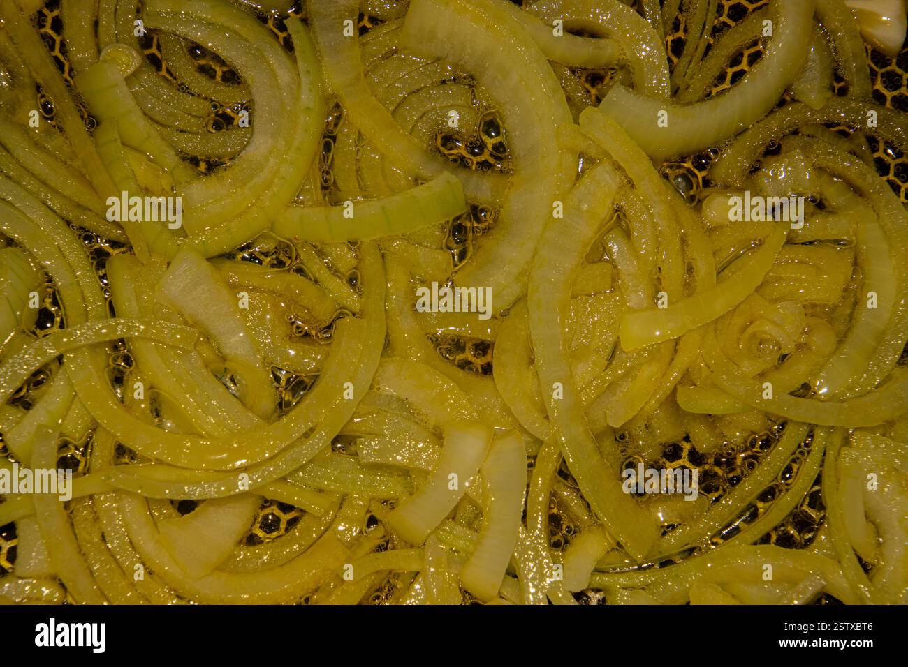 Cooking process featuring onion slices frying in hot oil, highlighting ...