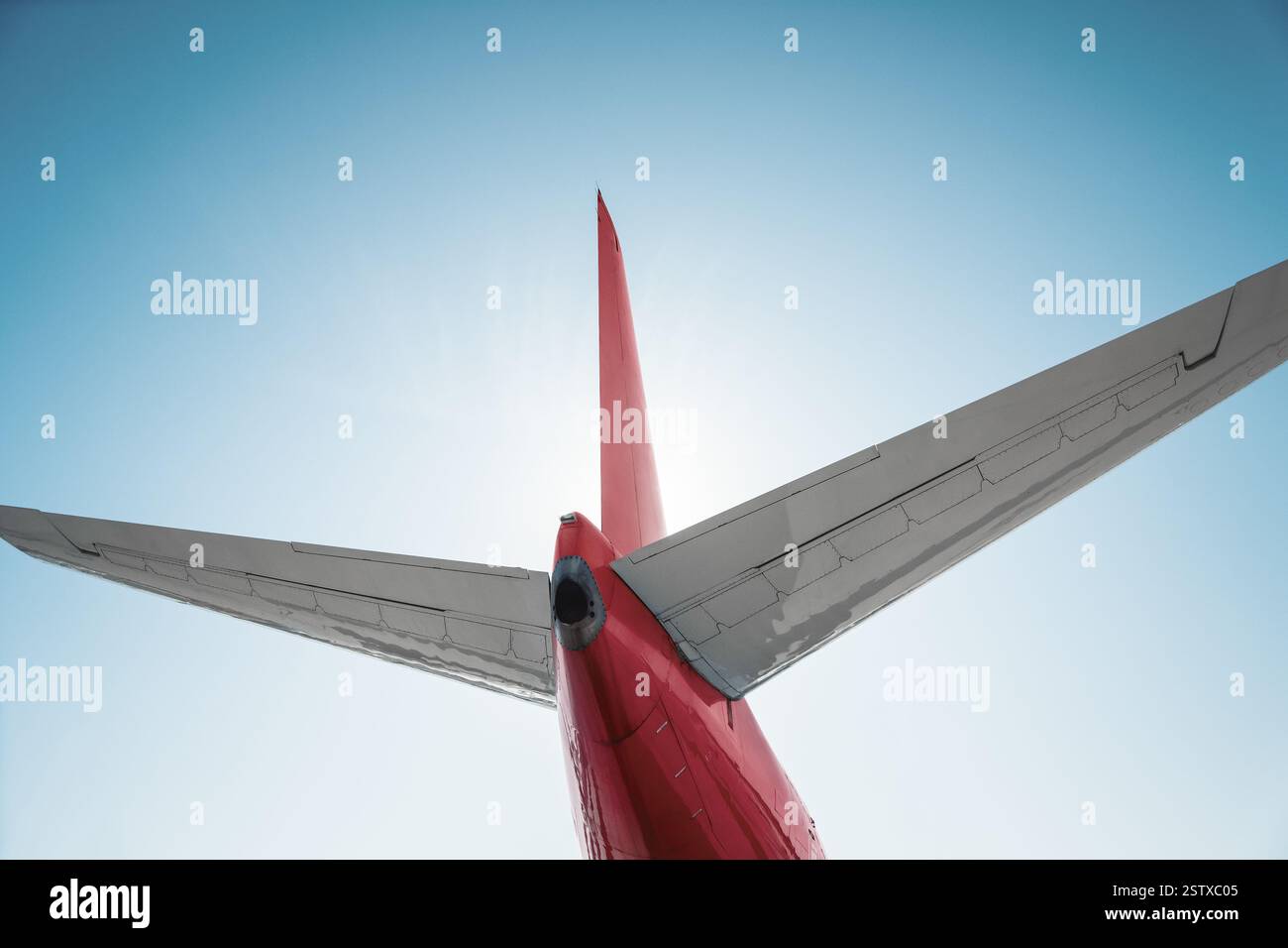 Low angle view. of a tail of a red airplane. Backlit shot of airplane ...