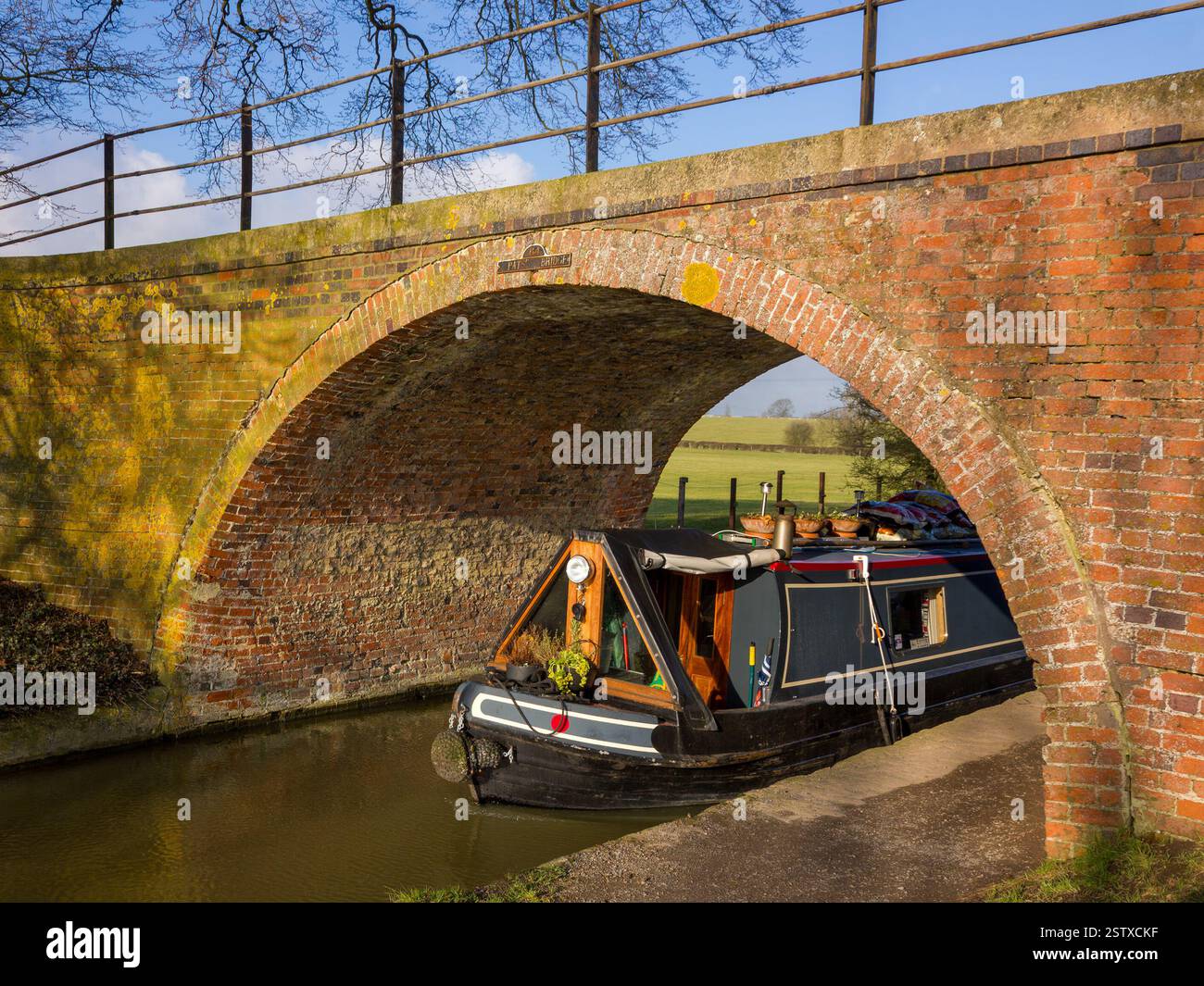 Barge / narrowboat and old brick bridge on the Leicester Line of the ...