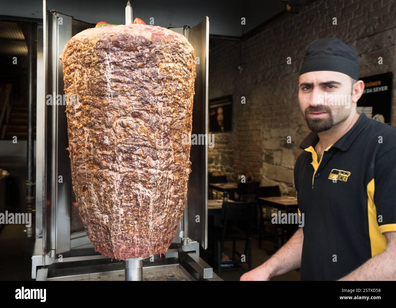 Doner Kebab seller stands next to his huge kebab in a shop in Istanbul ...