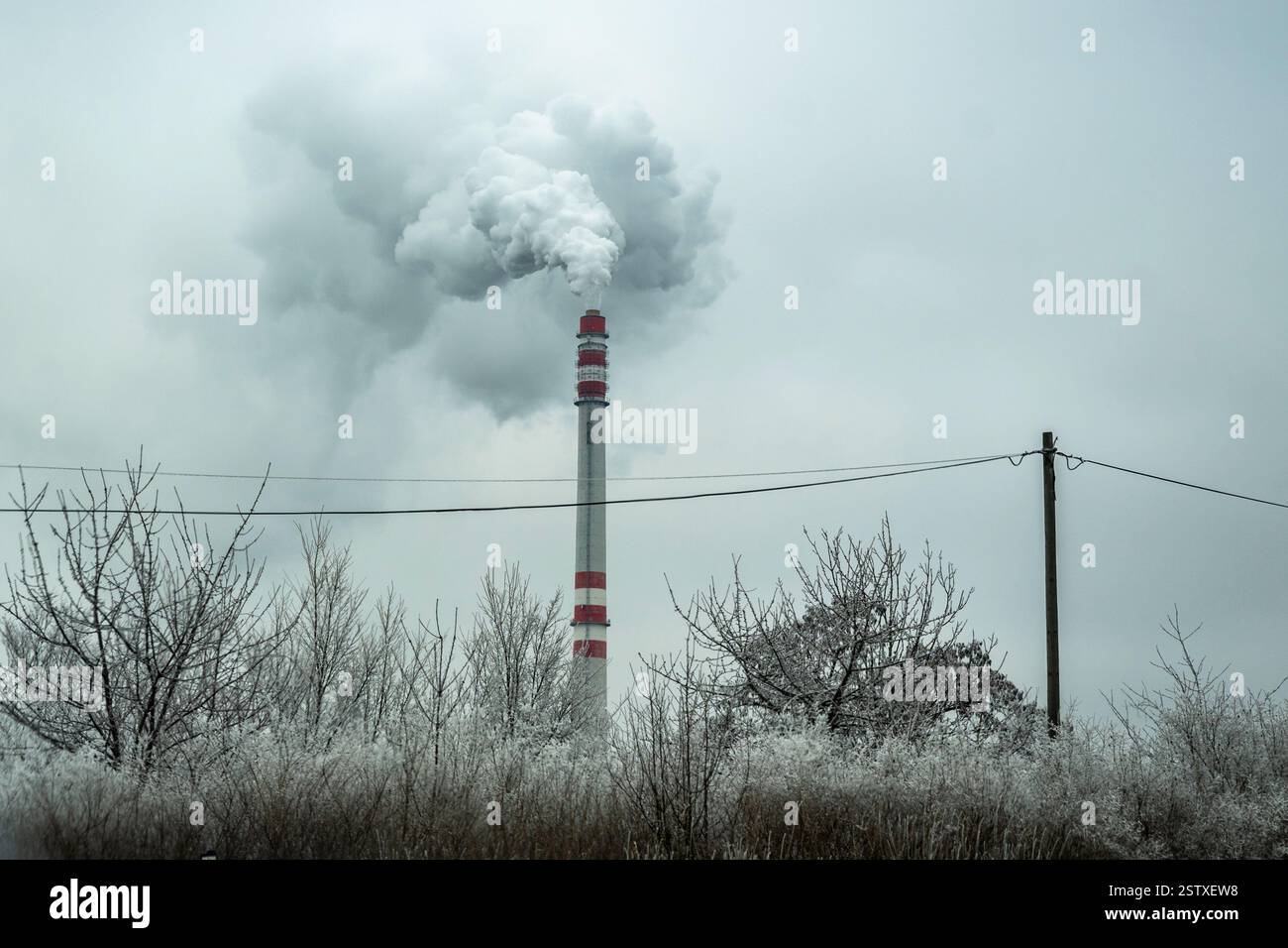 Smoking chimney from heating plant in dark inversion weather in winter ...