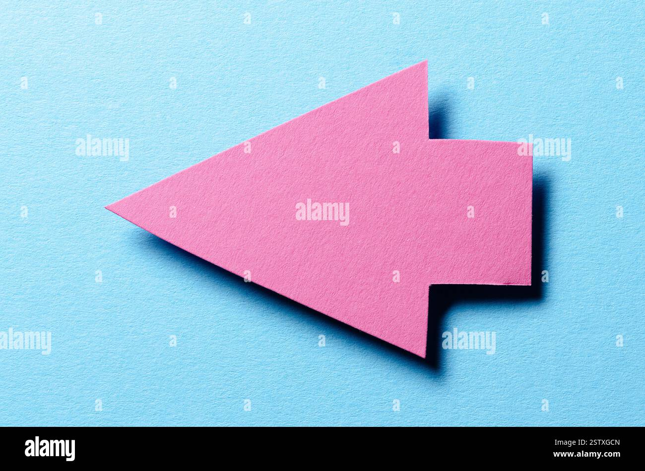 Pink cut out blank paper cardboard arrow direction sign with copy space ...