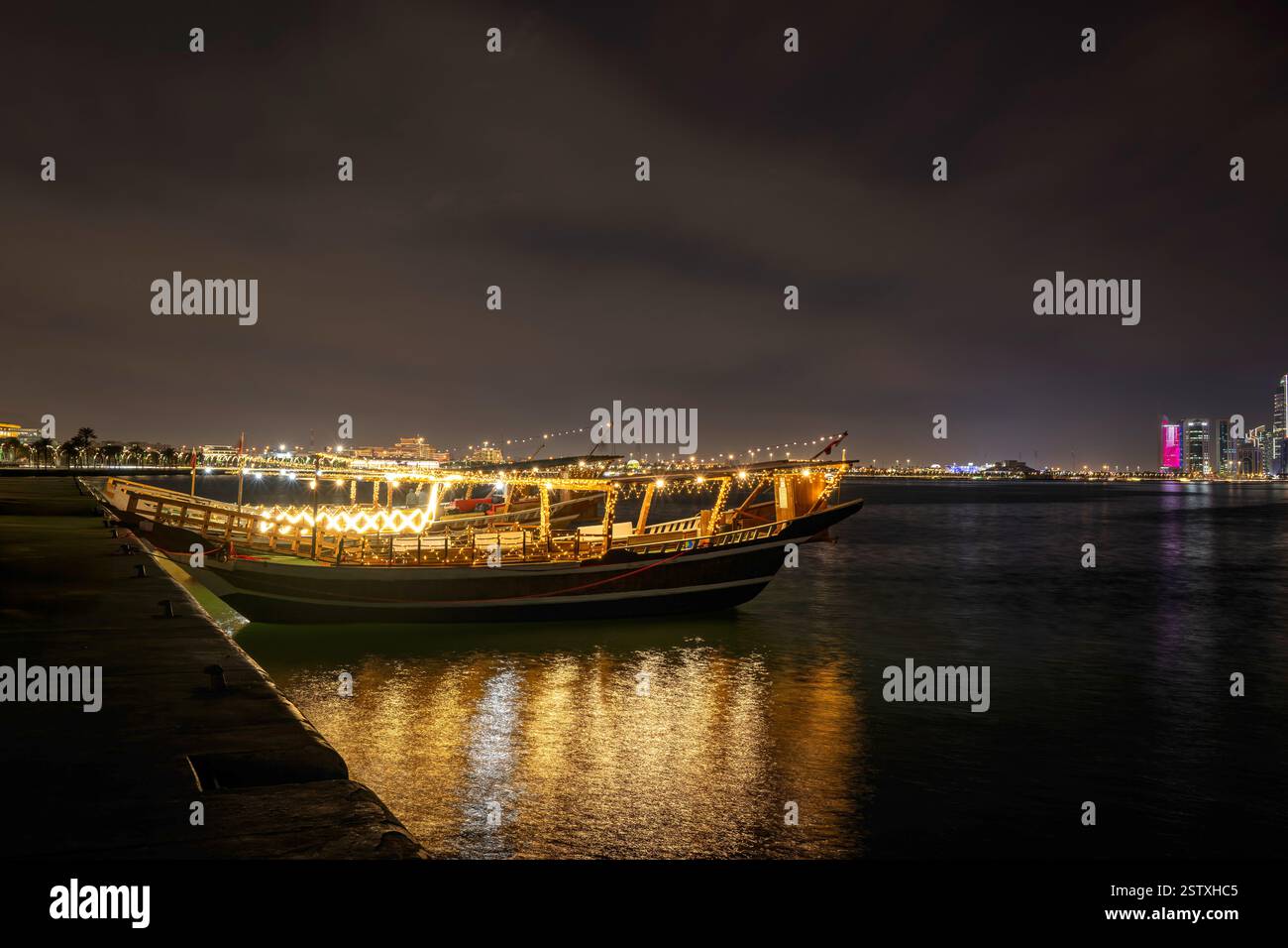 Night Doha city view, Arabic traditional cruise dhow boat docked at the ...