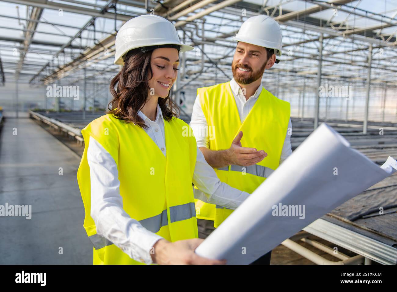 Engineers at the greenhouse construction site scrutinizing a ...