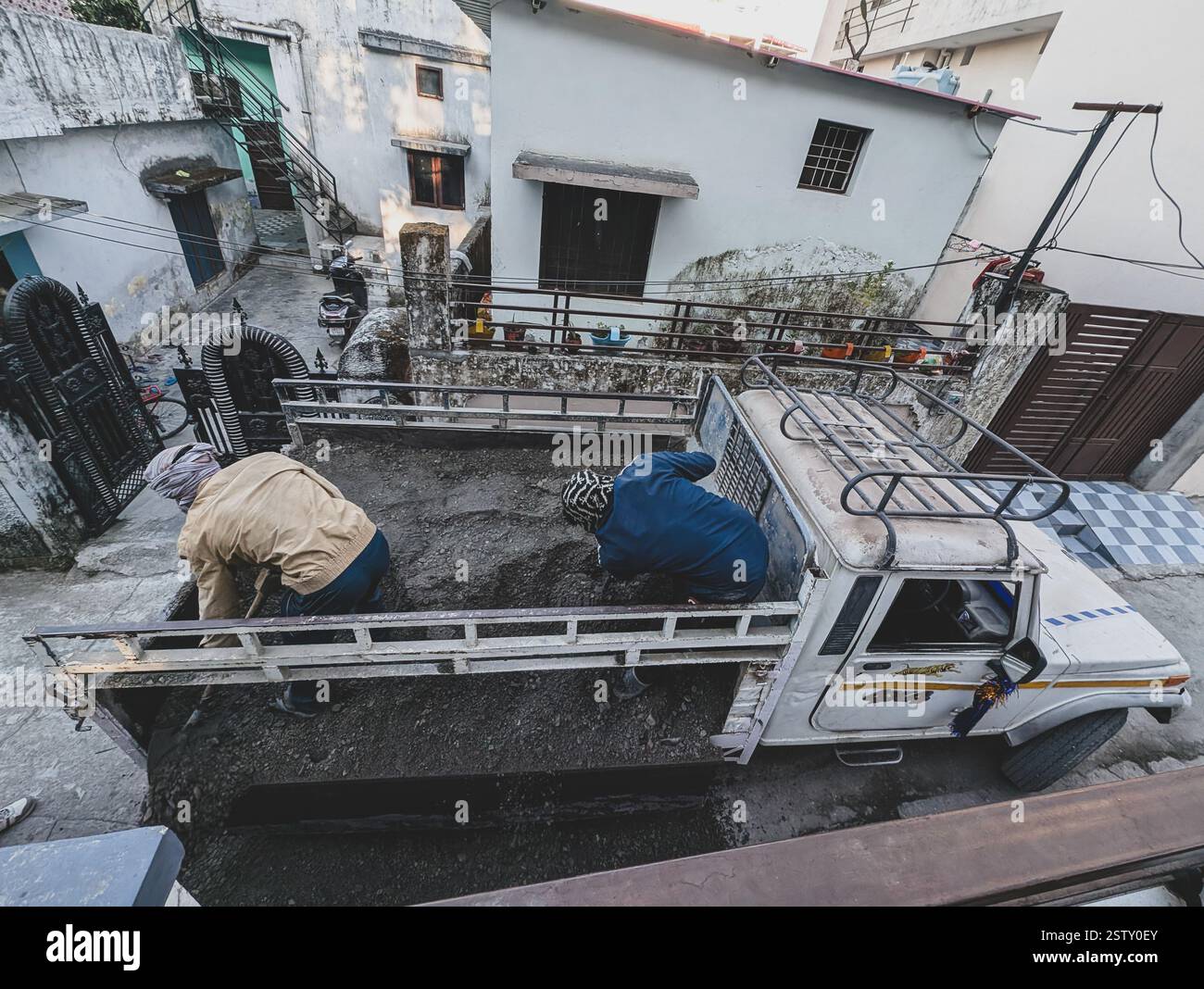 Feb15th2025 Dehradun Uttarakhand India. Manual labor unloading core sand and construction mortar ...