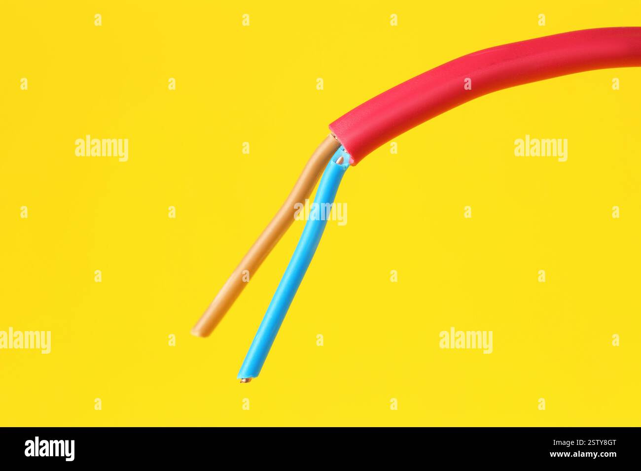 Red stripped electrical wire on yellow background, closeup Stock Photo ...