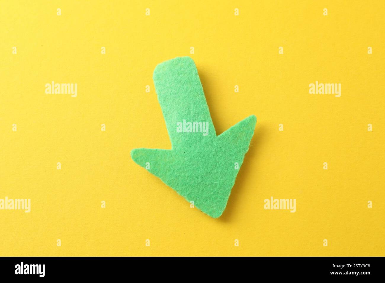 One green arrow on yellow background, top view Stock Photo - Alamy