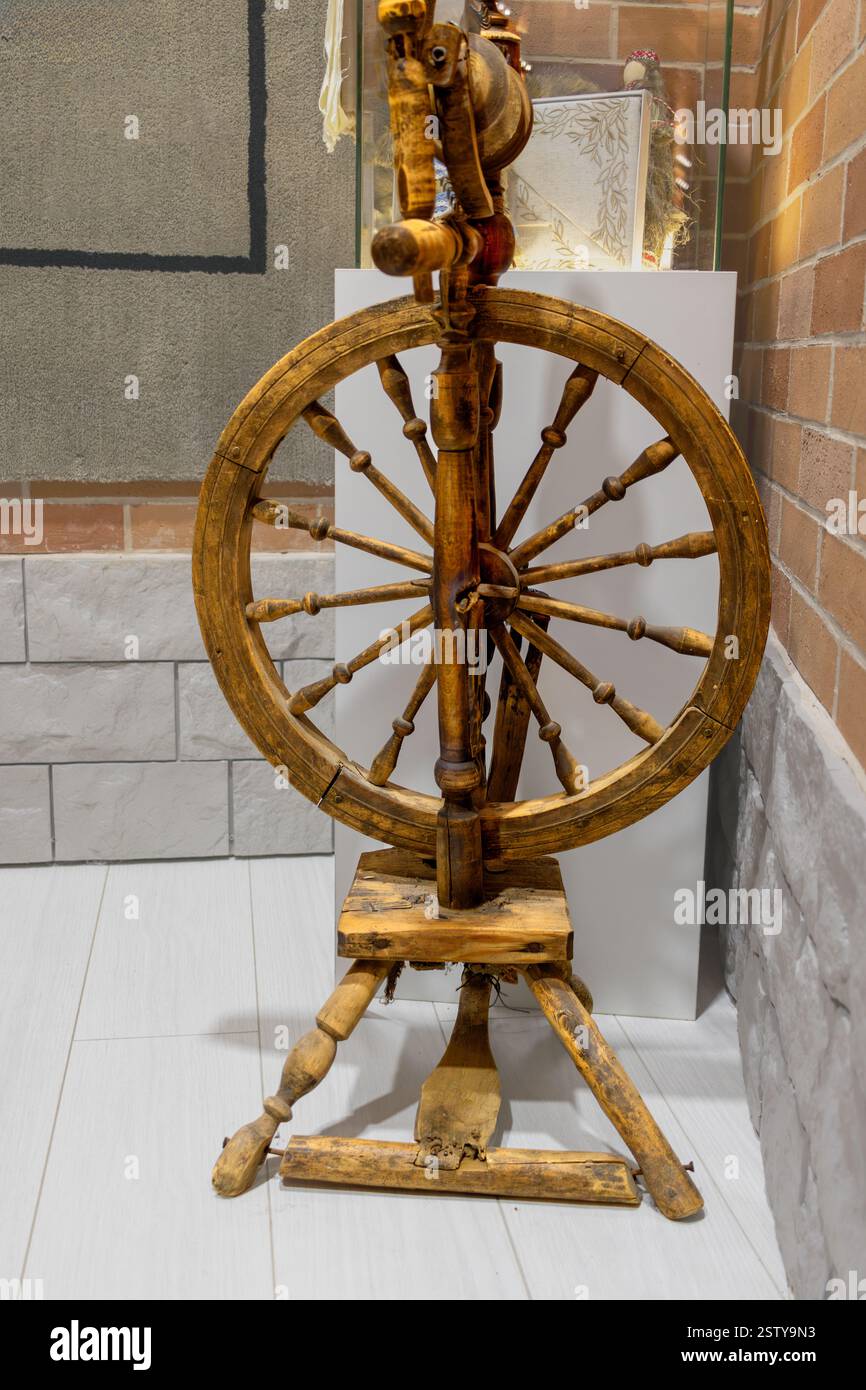An antique wooden spinning wheel. Vertical photo Stock Photo - Alamy