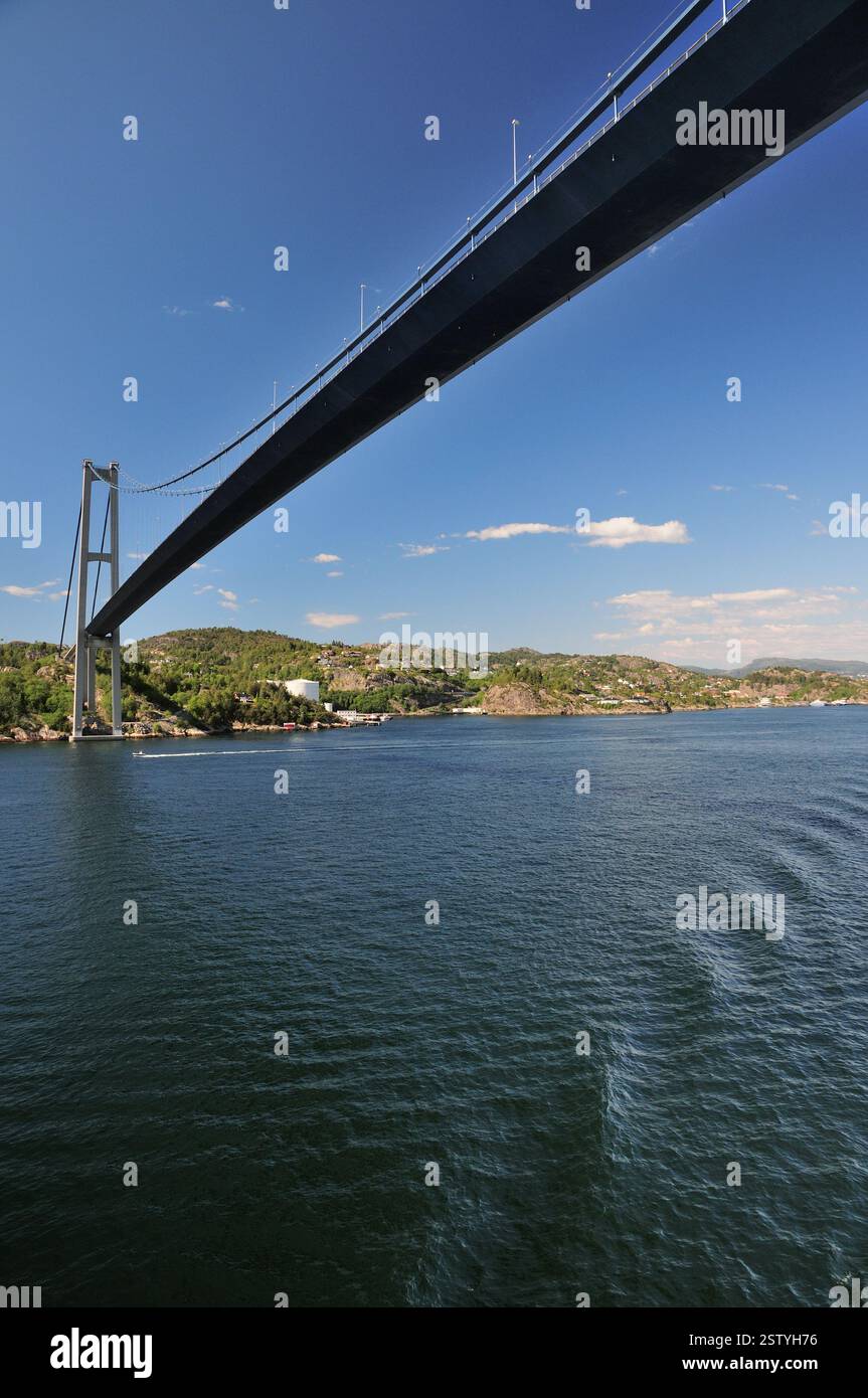 Sailing under a road suspension bridge at Bergen in western Norway ...