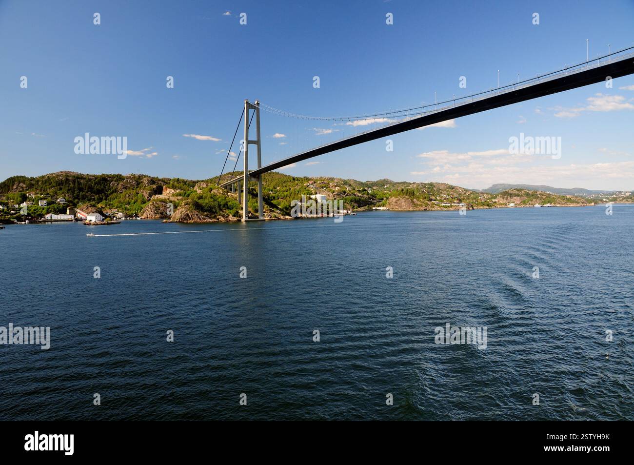 Sailing under a road suspension bridge at Bergen in western Norway ...