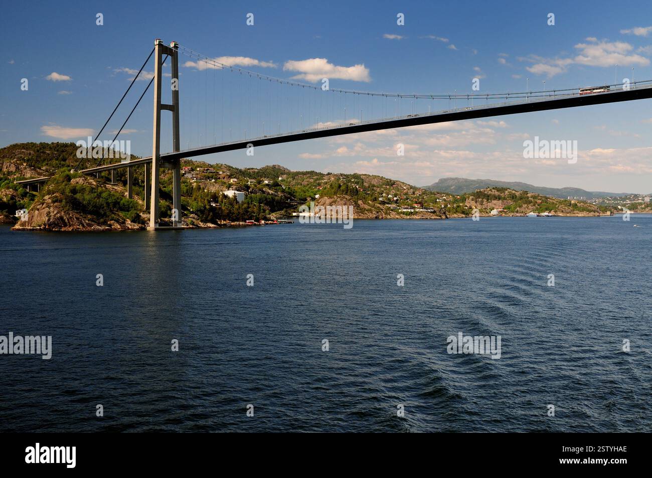 Sailing under a road suspension bridge at Bergen in western Norway ...