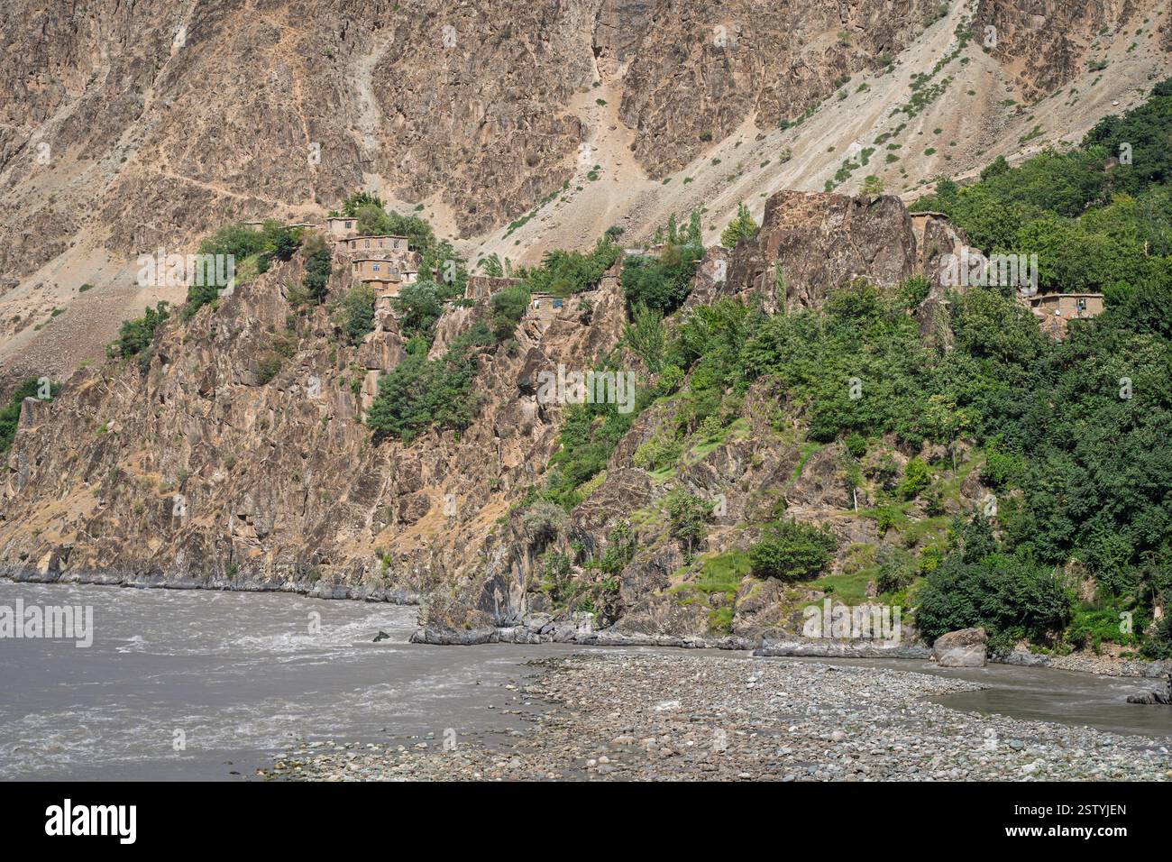 Mountain landscape view of remote Afghan village on rocky cliff in Panj ...