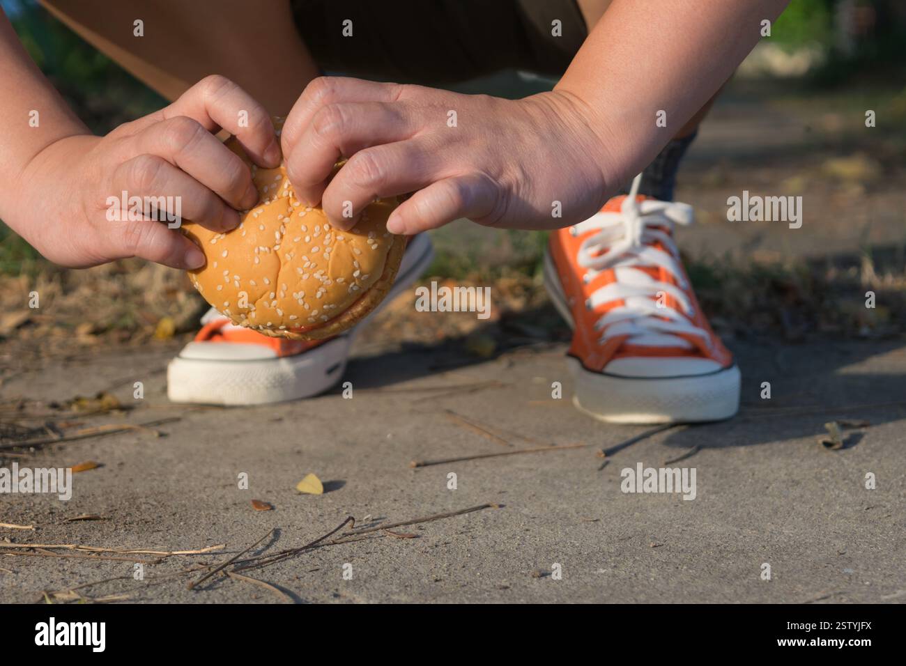 Good bye junk food hamburger left to jogging exercise Stock Photo - Alamy