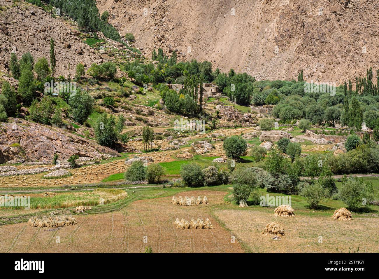 Rural mountain landscape view with fields and straw bales in Panj river ...