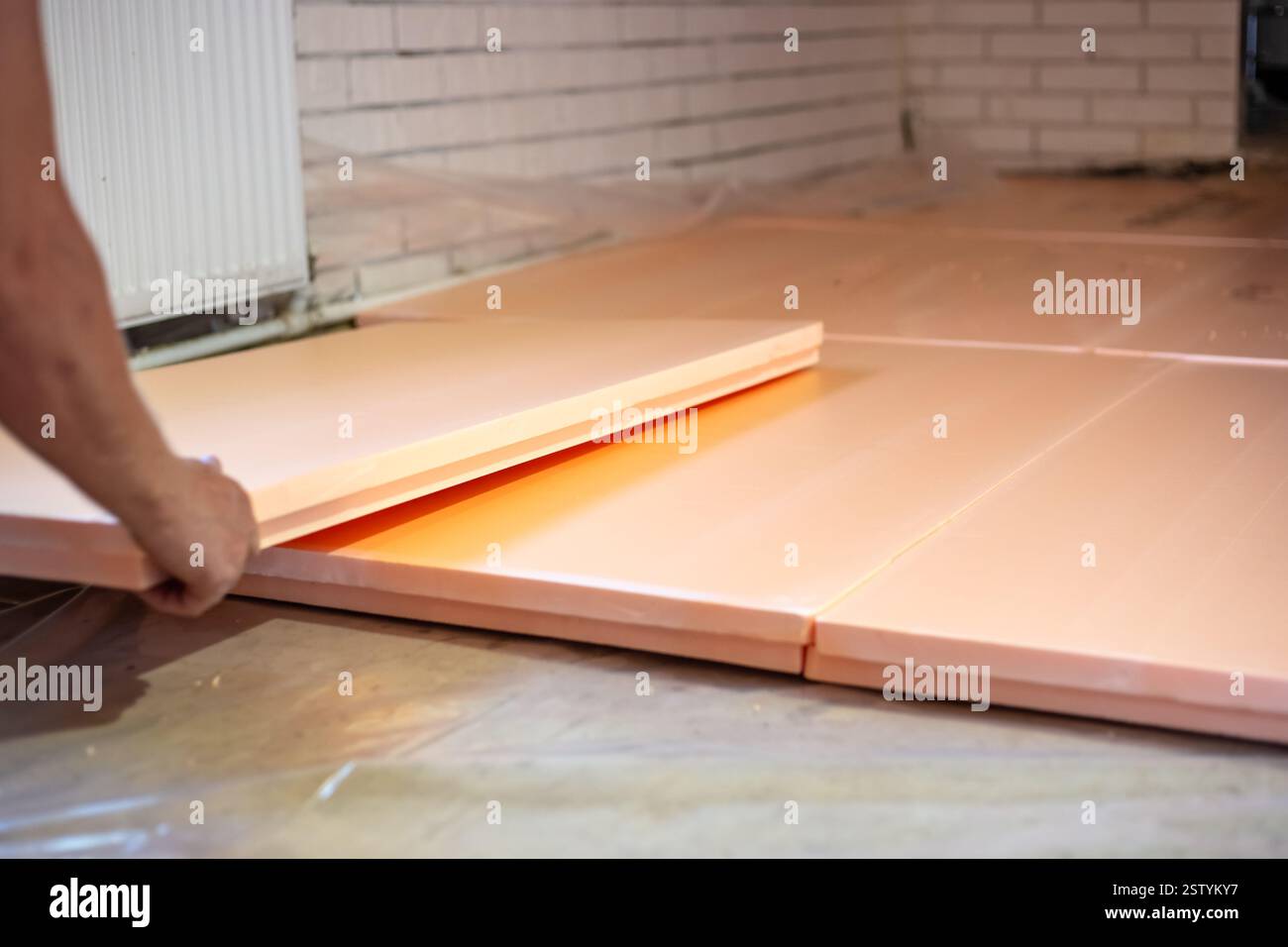 Worker lays polystyrene foam on the floor. Insulation of the house ...