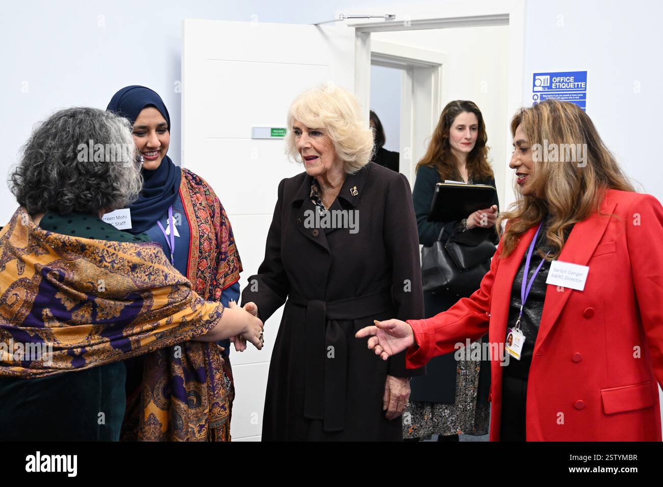 Queen Camilla (centre) meets staff during a visit to the Asian Women's ...