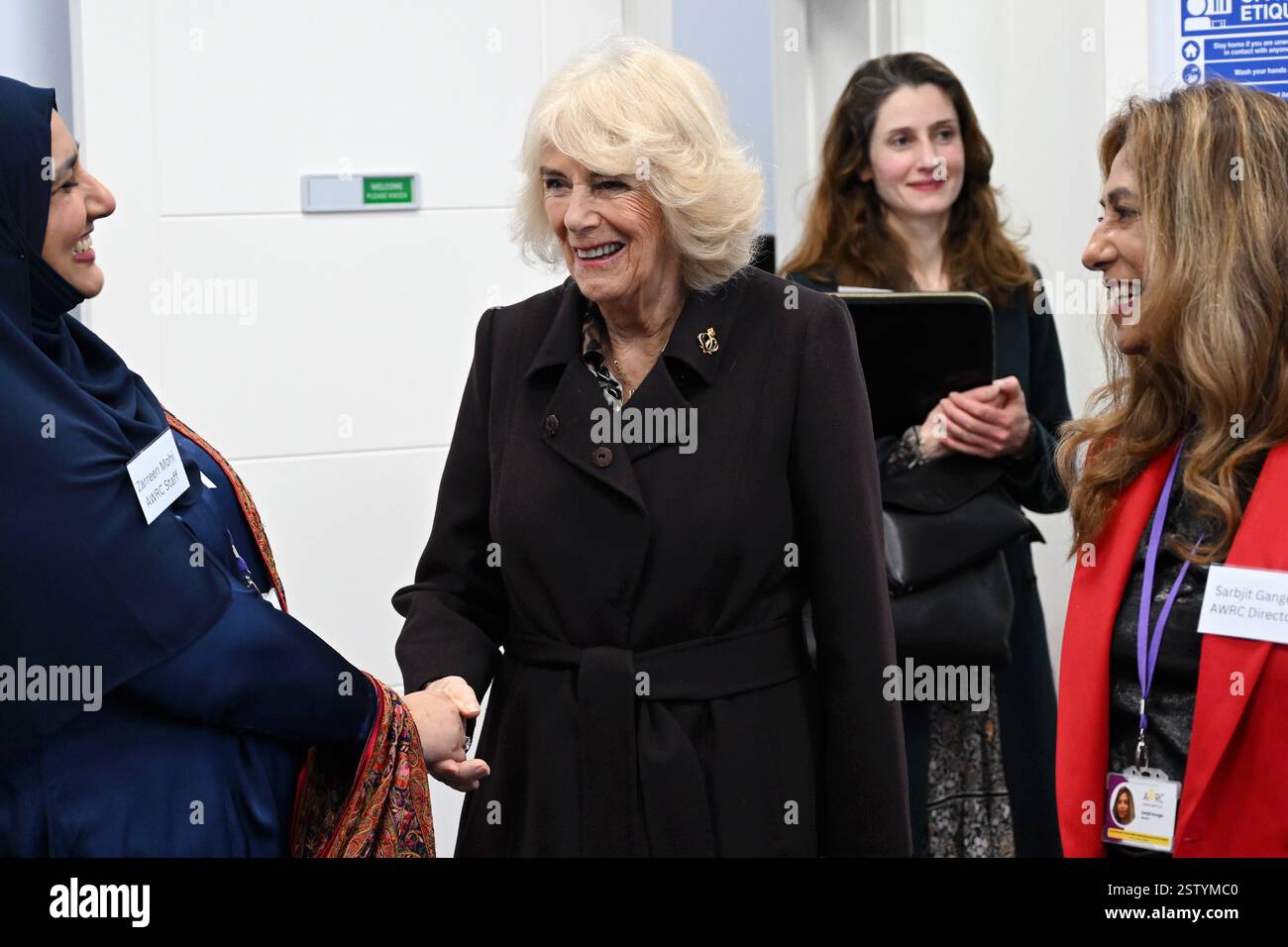 Queen Camilla (centre) meets staff during a visit to the Asian Women's ...