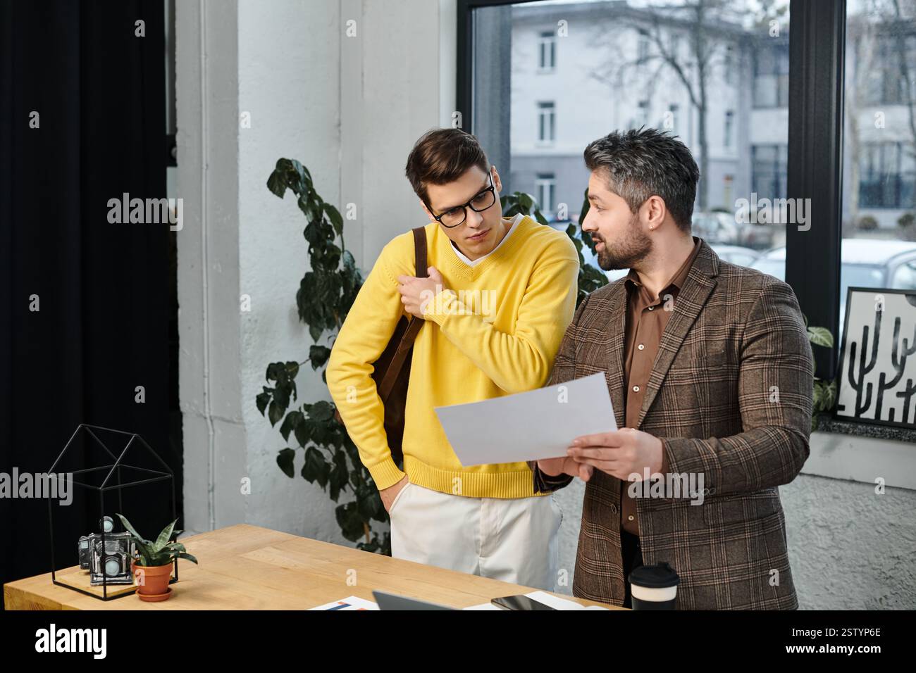 Two colleagues engage in a discussion as one receives guidance on ...