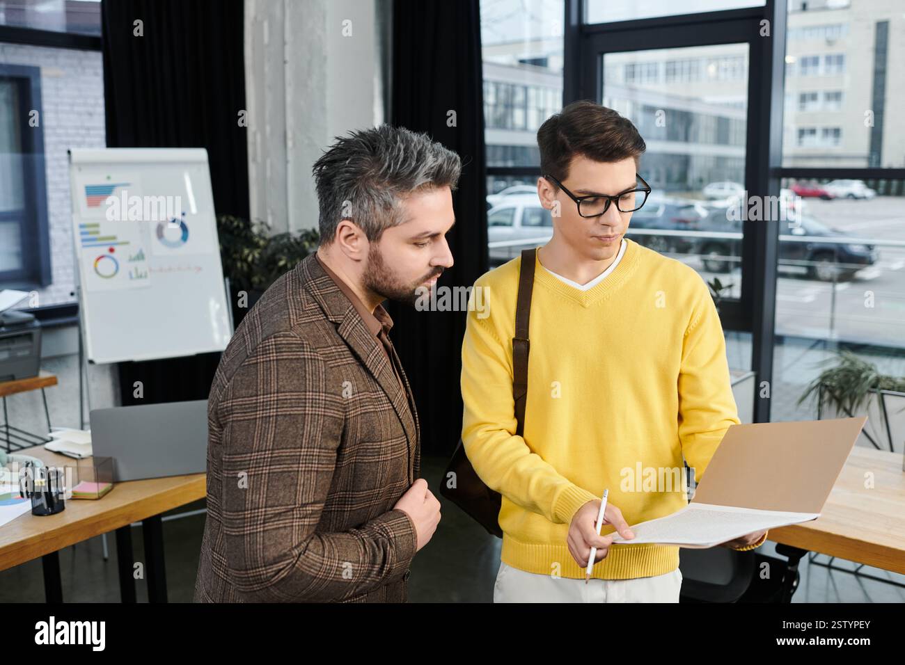 Two professionals collaborate during onboarding in a contemporary office space filled with light ...