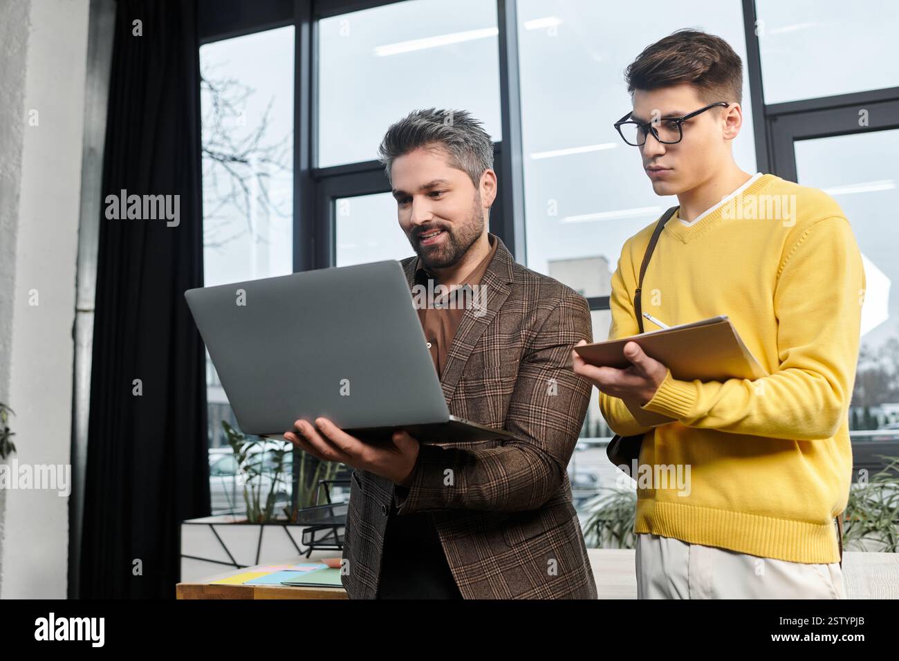 Two colleagues engage in a collaborative onboarding session, reviewing ...