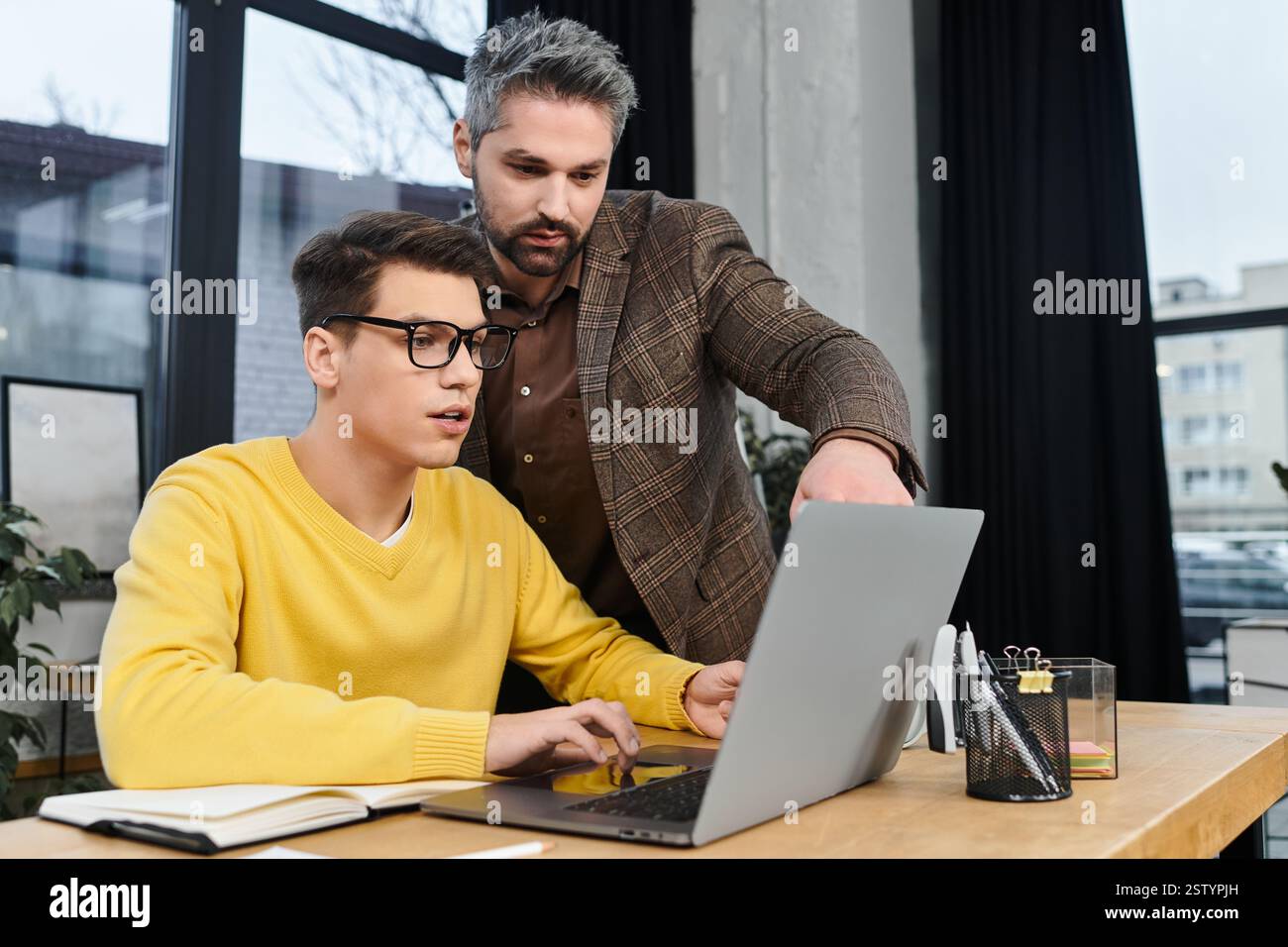 Mentor helps a new team member adjust on his first day at work Stock ...
