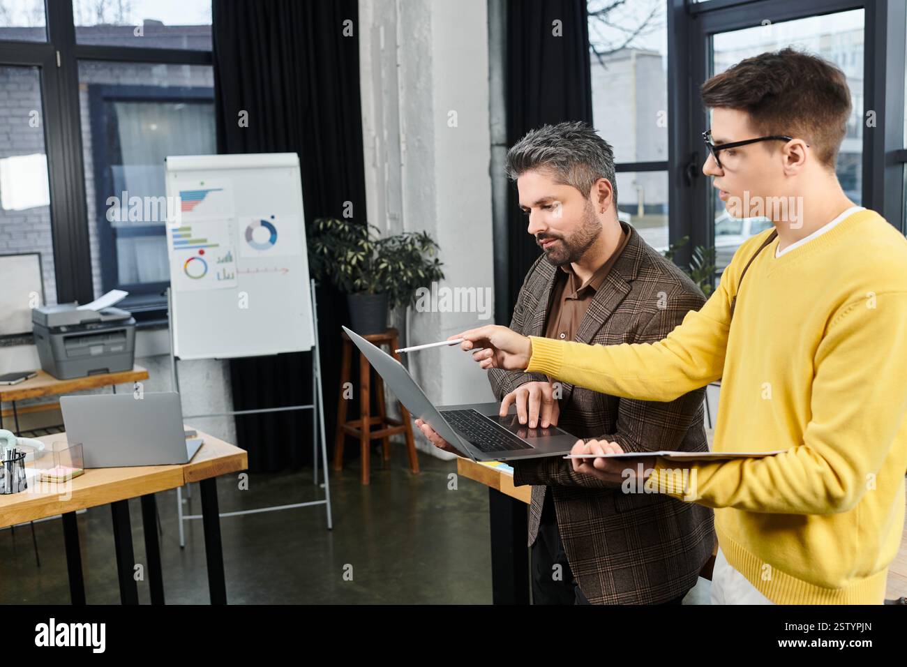 Two employees collaborate in an office during an onboarding session ...