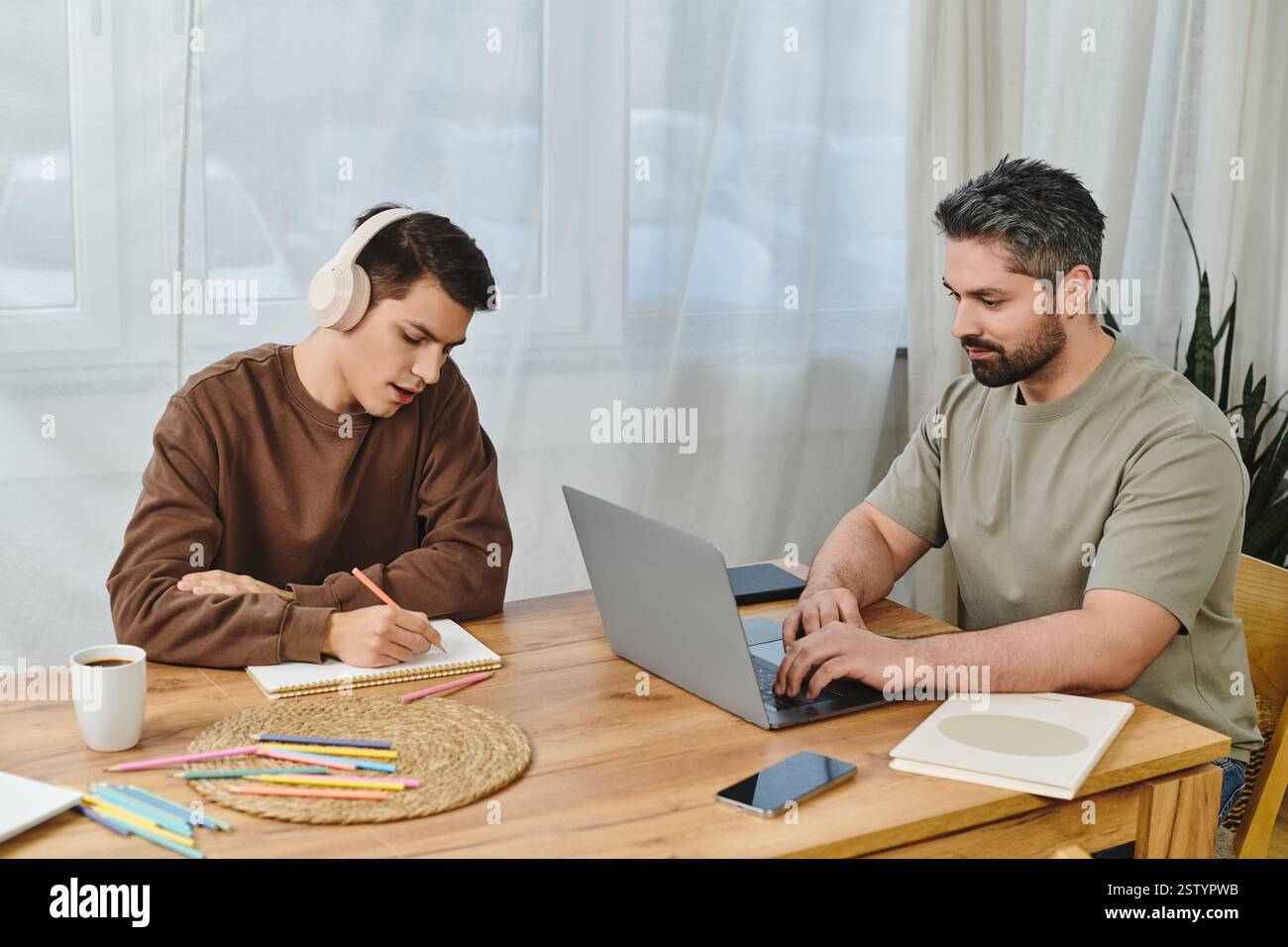 Two brothers engage in focused study activities at home, sharing ideas ...