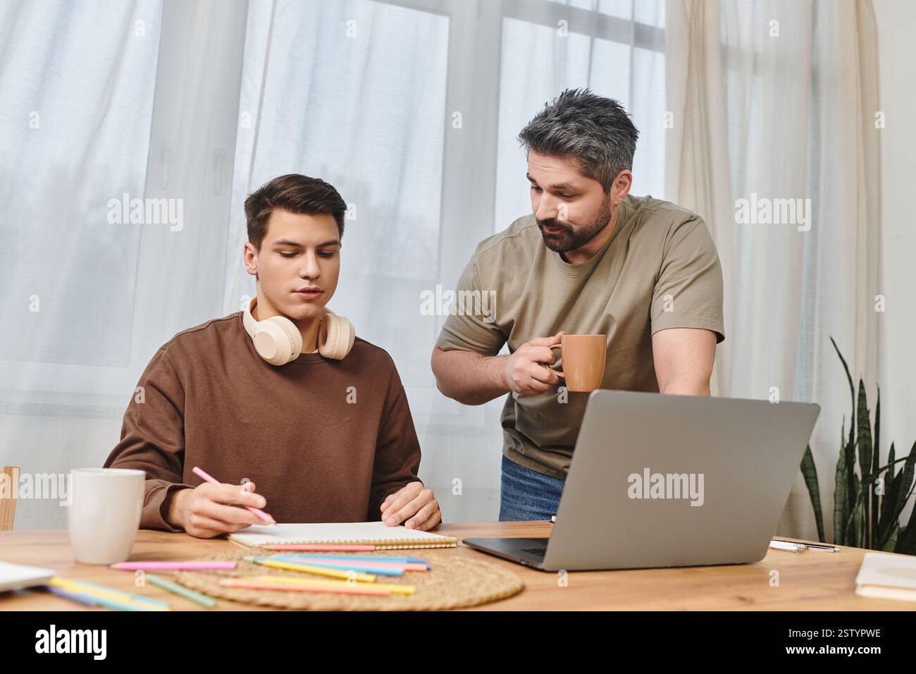 Two brothers engage in an inspiring home study session filled with conversation and ideas Stock ...