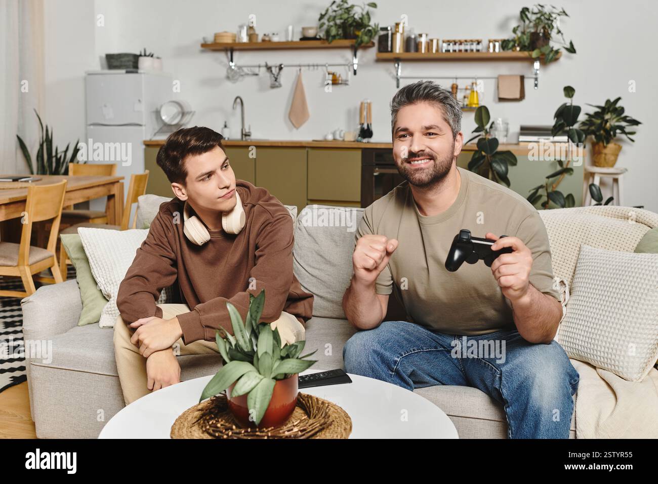Two brothers share a cozy moment at home while enjoying a game and each ...