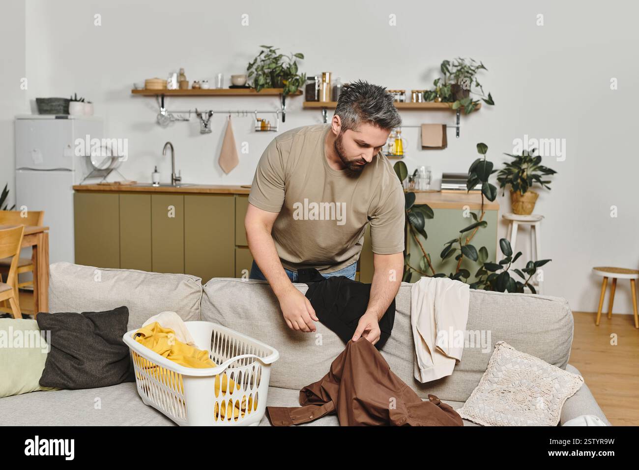 A man enjoys a relaxing afternoon at home, carefully sorting clothes ...