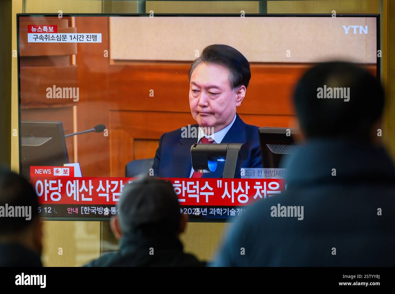 A 24-hour YTN TV broadcast at Seoul Railway Station shows a news broadcast with impeached South ...