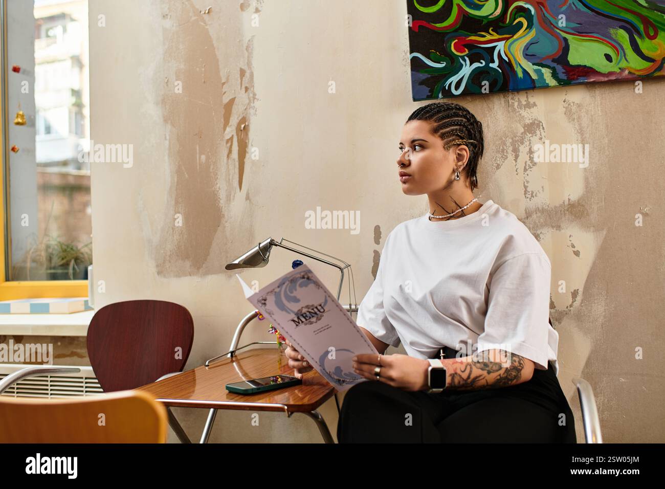Stylish woman with unique hairstyle thoughtfully reviews the menu in a ...