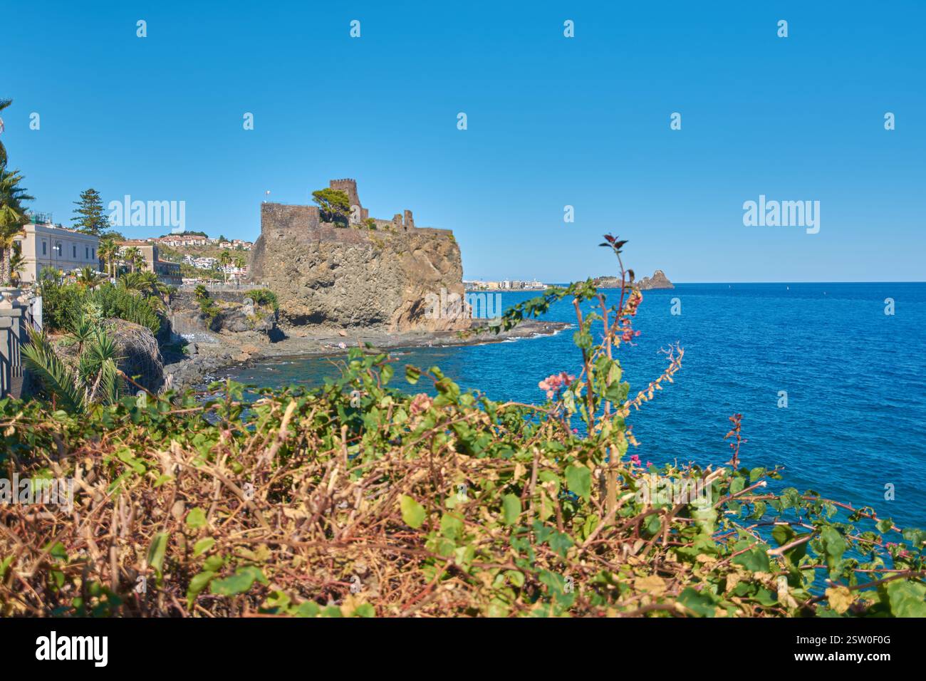 Coastal scene with a historic castle overlooking the sea, vibrant pink ...
