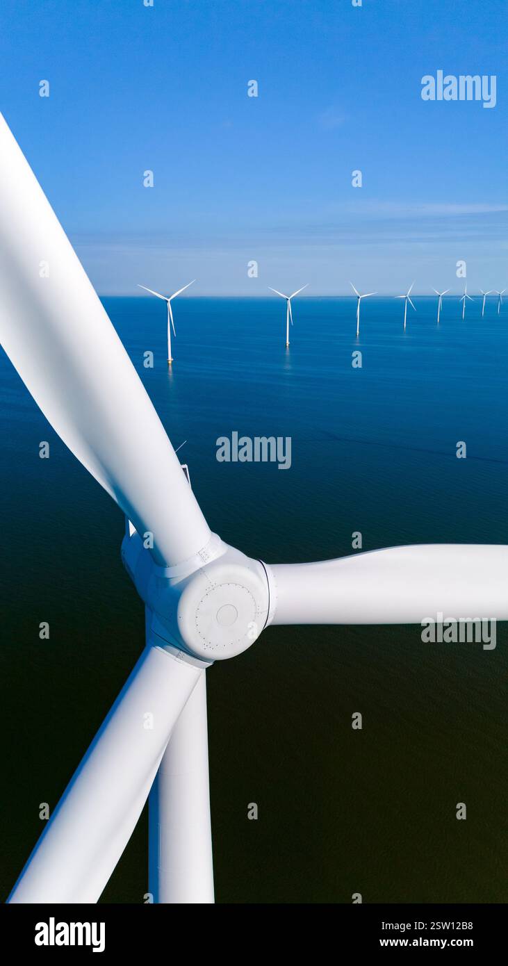Giant turbines harnessing wind energy stand tall against the azure sky, creating renewable power ...