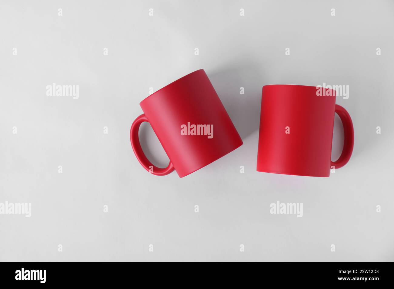 Two blank red mugs on white background, top view. Mockup for design ...