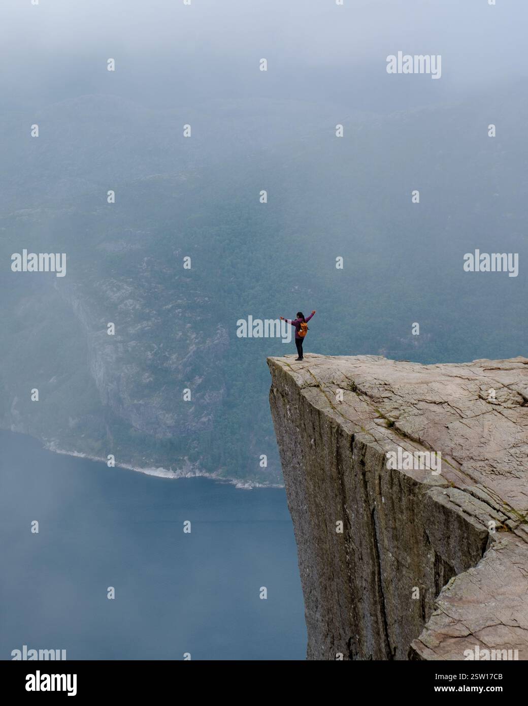 Daring Adventurer Standing on Pulpit Rock Overlooking Norway's Majestic ...