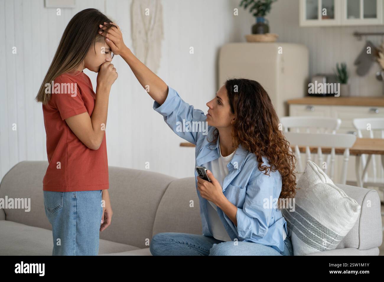 Worried woman mother touching sick child forehead, Kids health during flu season Stock Photo - Alamy