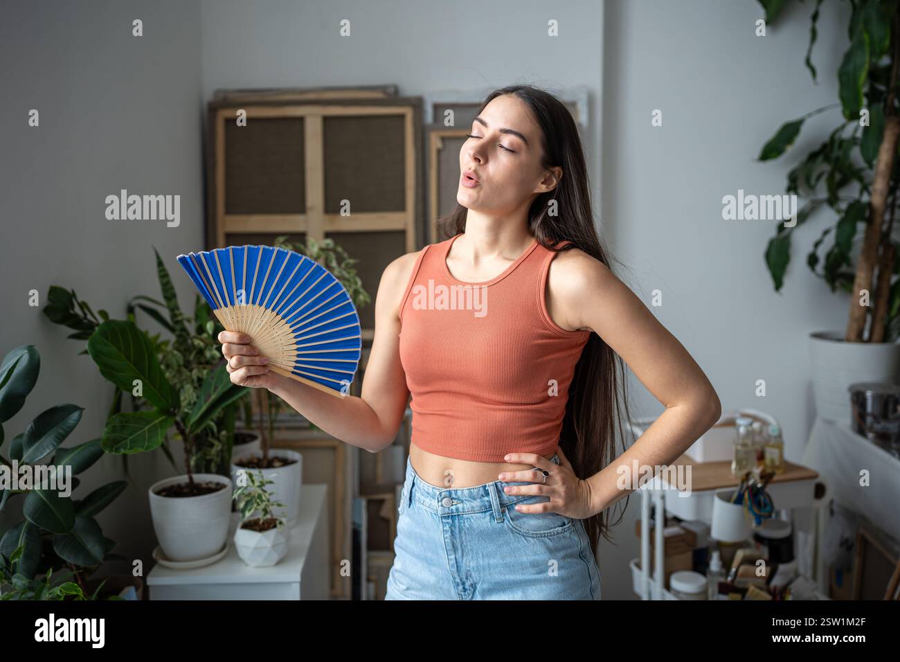 Tired unhappy overheated woman fanning herself suffering from summer ...