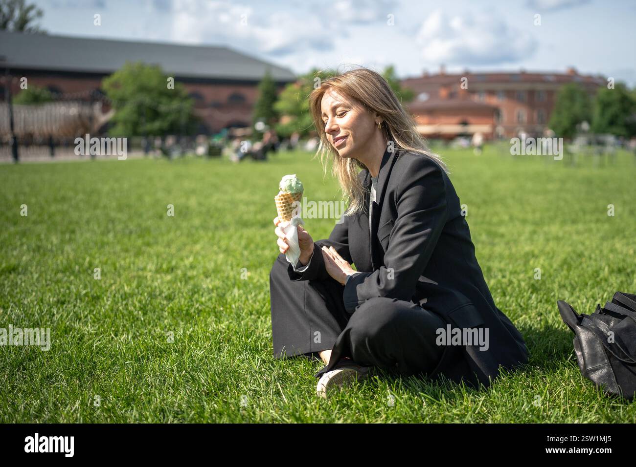 Happy smiling woman in costume suit eating ice cream, relaxing sitting ...
