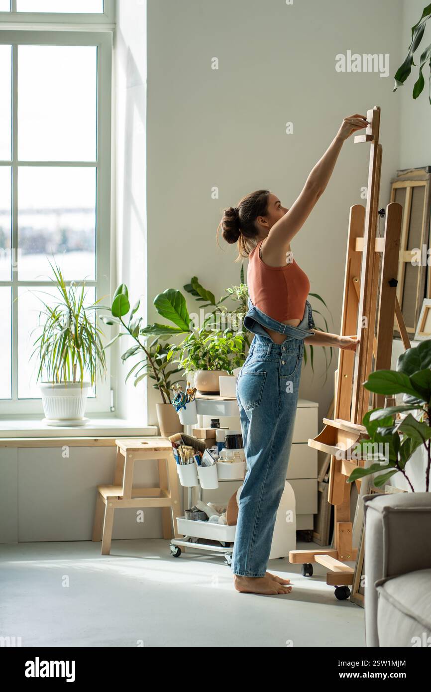Inspired woman artist preparing easel before work painting process in ...