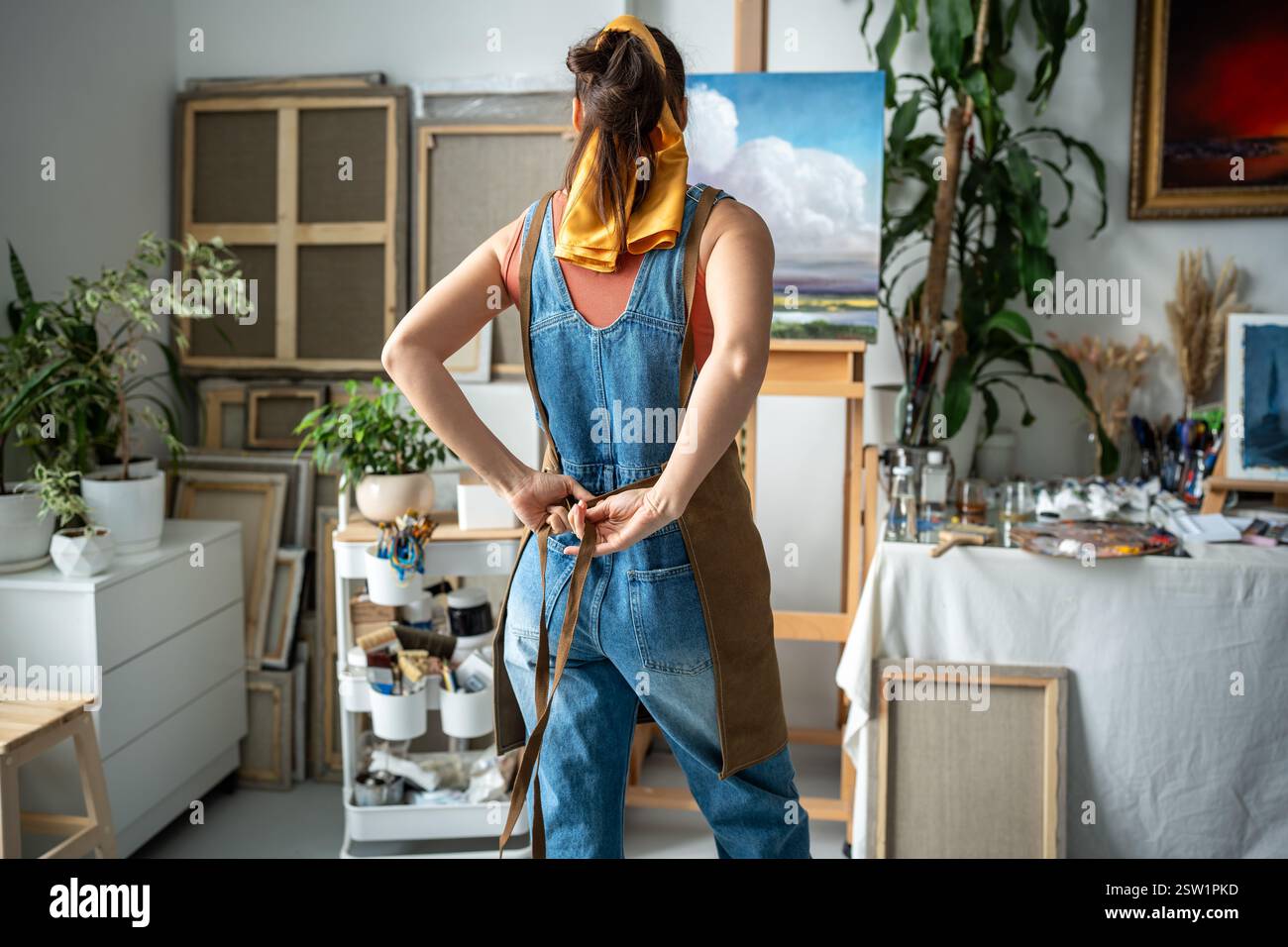 Woman painter tying apron getting ready for creative work. Female ...
