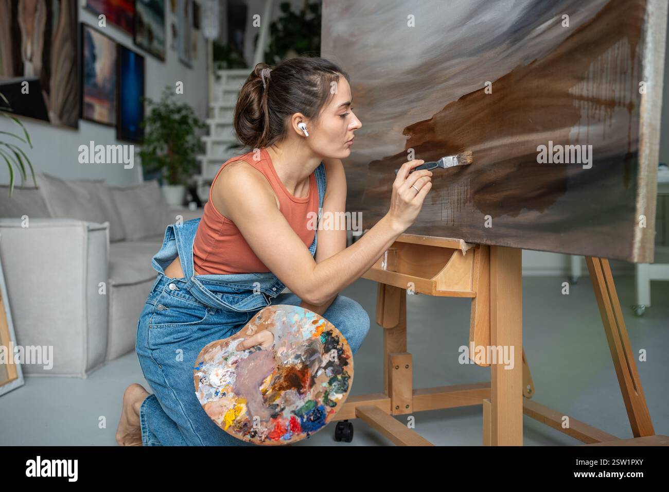 Professional female artist in light art studio painting picture ...