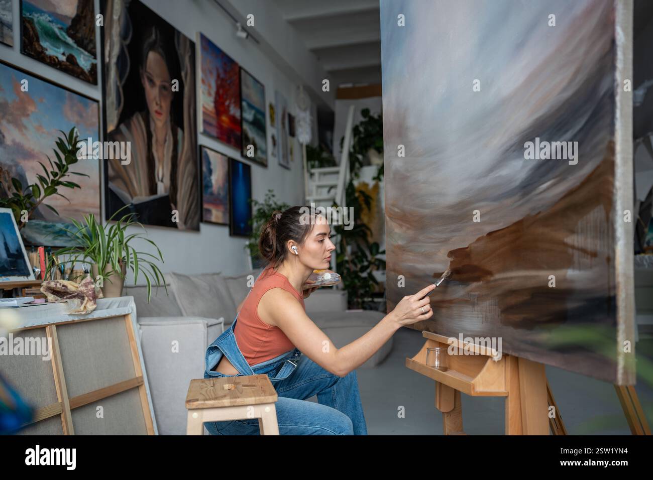Professional female artist in light art studio painting picture ...
