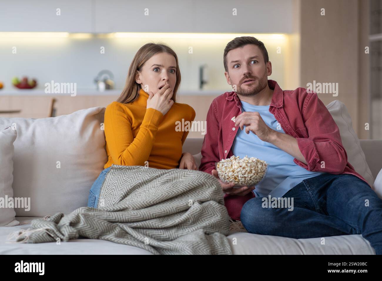 Scared married couple watching horror movie series about TV relaxing on ...