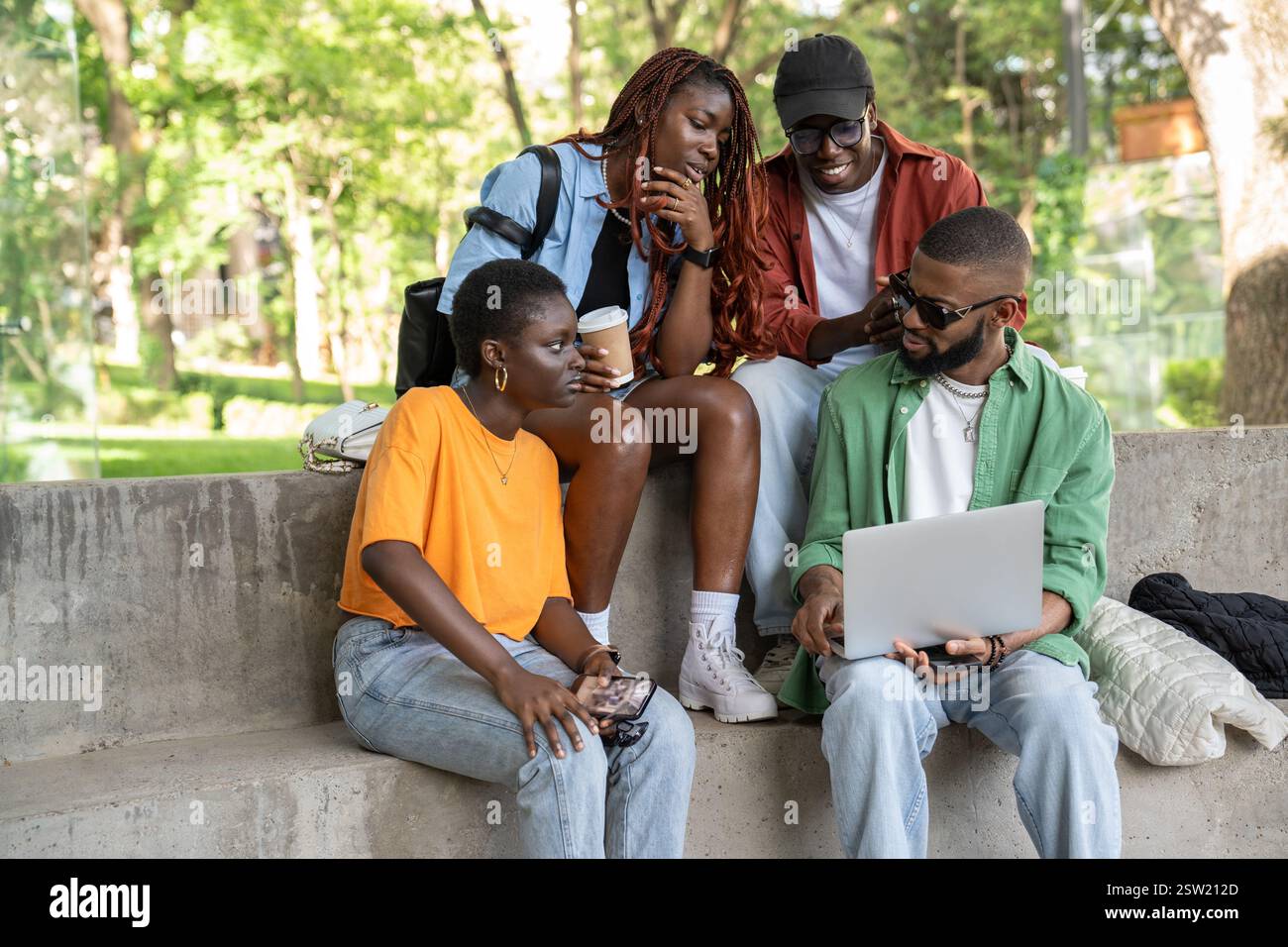 Satisfied pleased friends classmates studying together with laptop ...