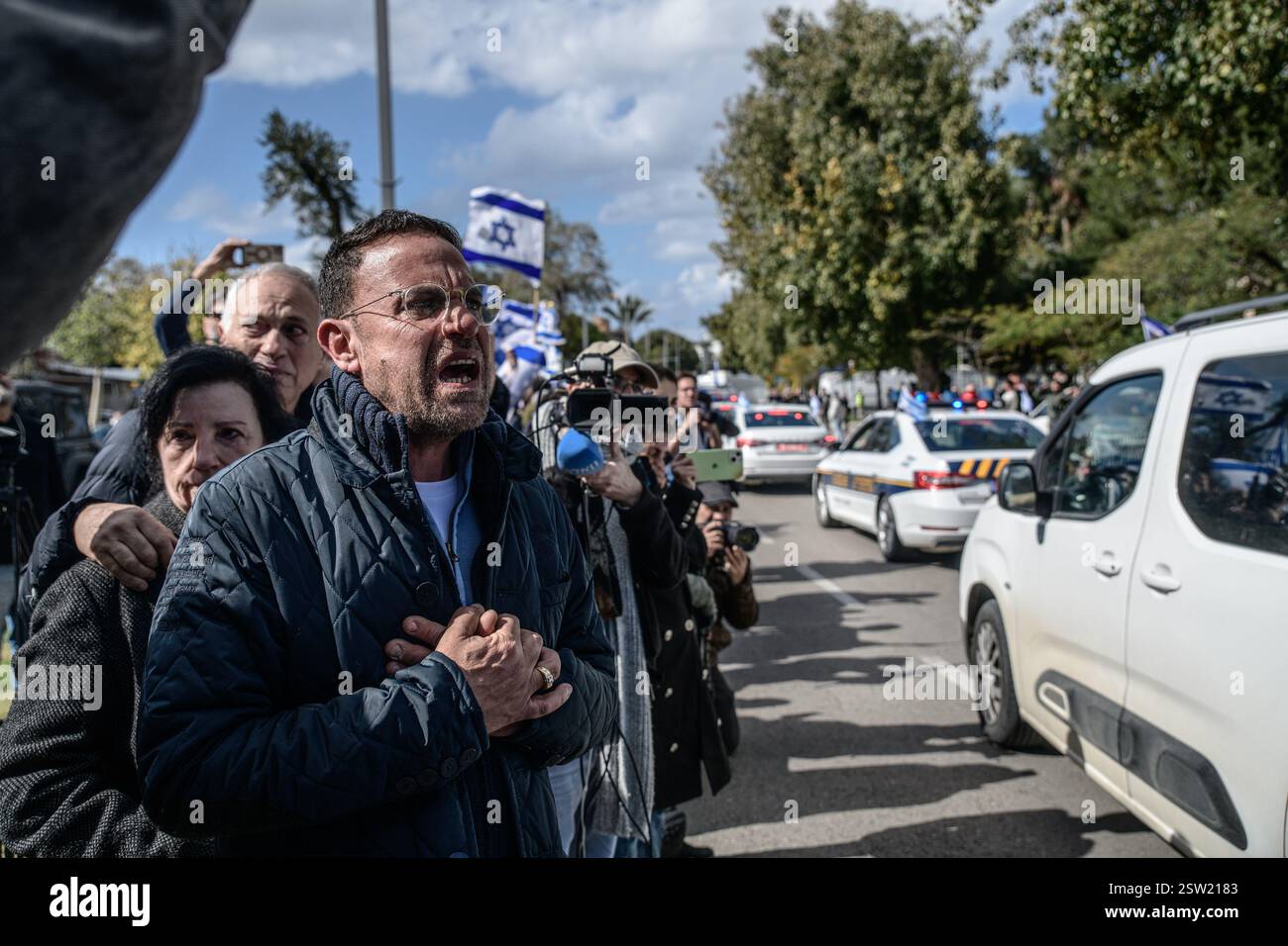 Israeli citizens salute while shouting “We’re sorry!” as the bodies of ...