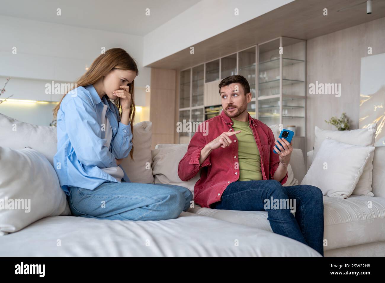 Crying upset woman with head in hands and boyfriend sitting together on ...